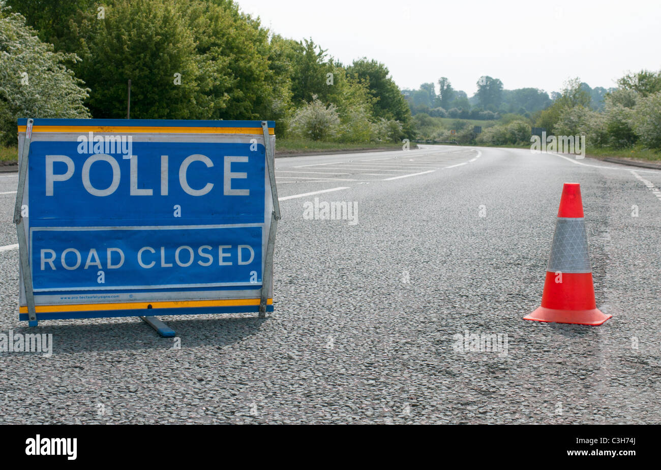 Blue Police Road Closed Sign with Bollard on Tarmac Road Stock Photo ...