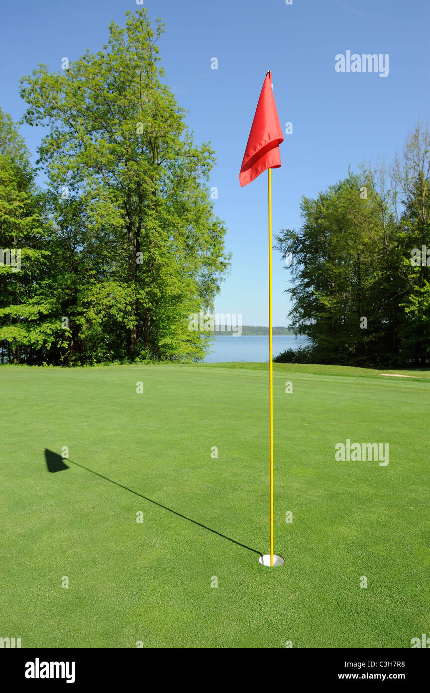 Golf course with flag at a lake Stock Photo - Alamy