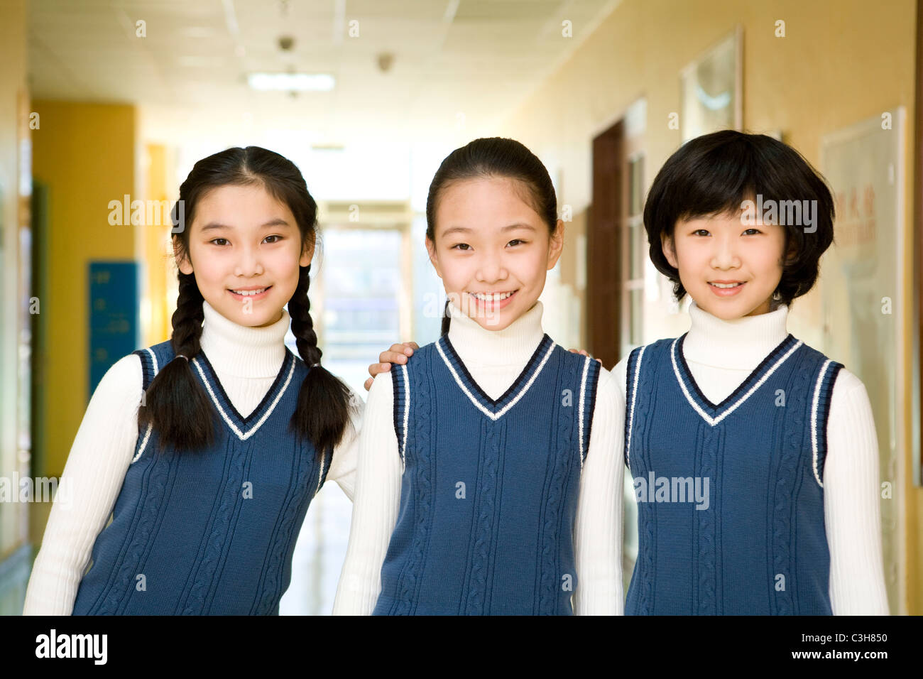 Three female students standing side by side smiling at school Stock ...