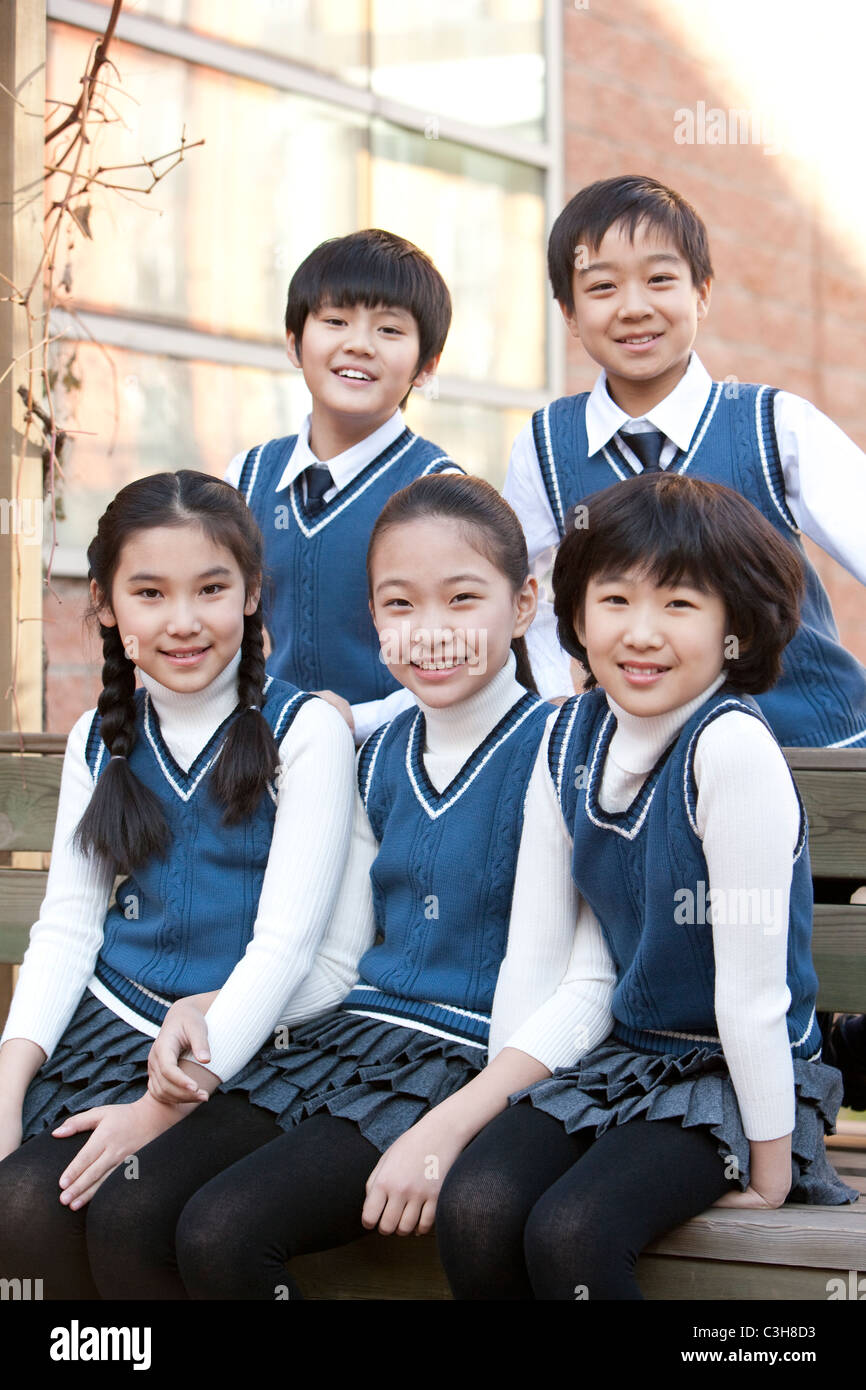 Five students sitting together on a bench Stock Photo - Alamy