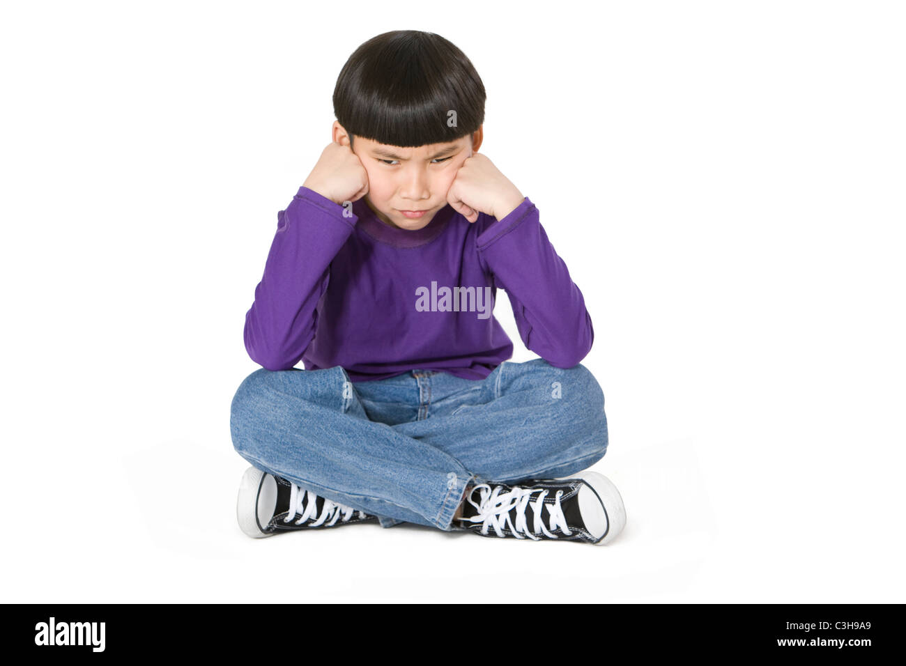 Young boy sitting and pouting Stock Photo - Alamy