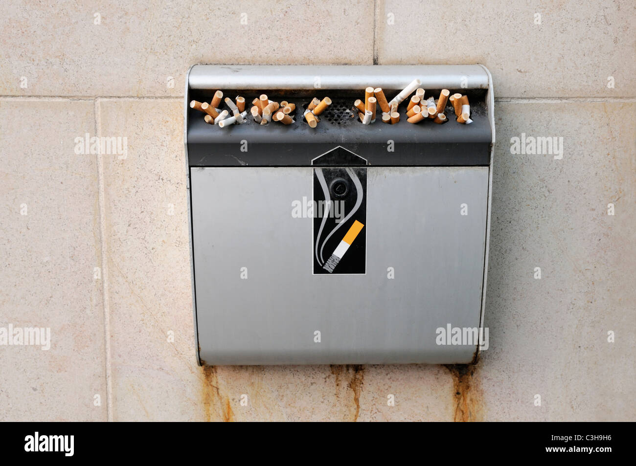 Cigarette stubs in outside bin Stock Photo - Alamy