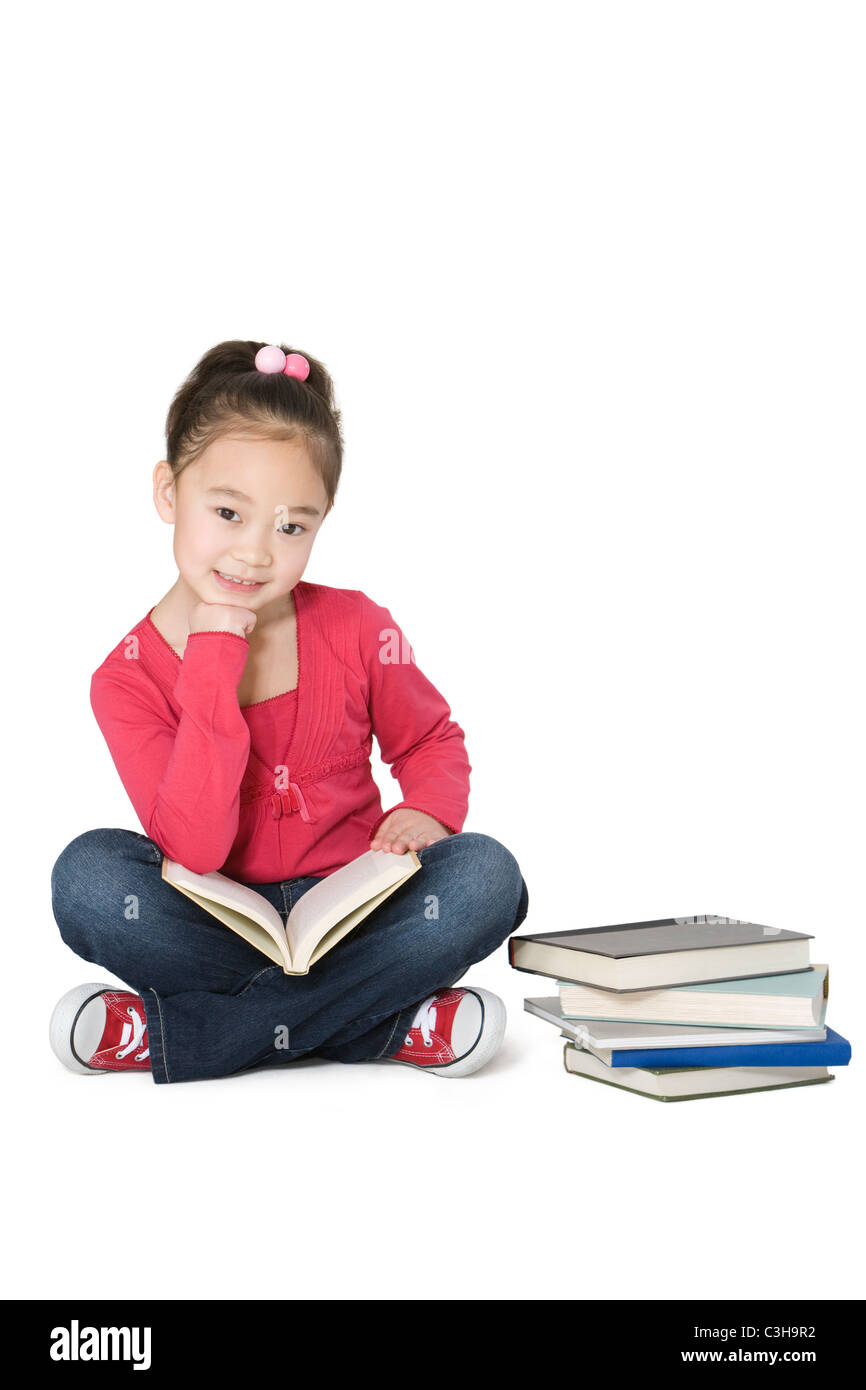 Young girl sitting and reading Stock Photo - Alamy