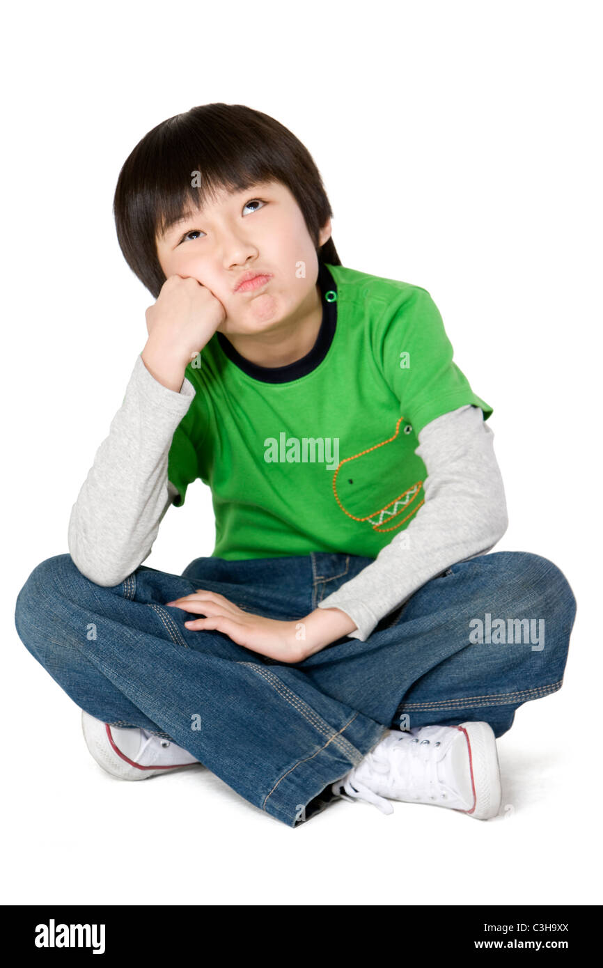 Young boy sitting and pouting Stock Photo - Alamy