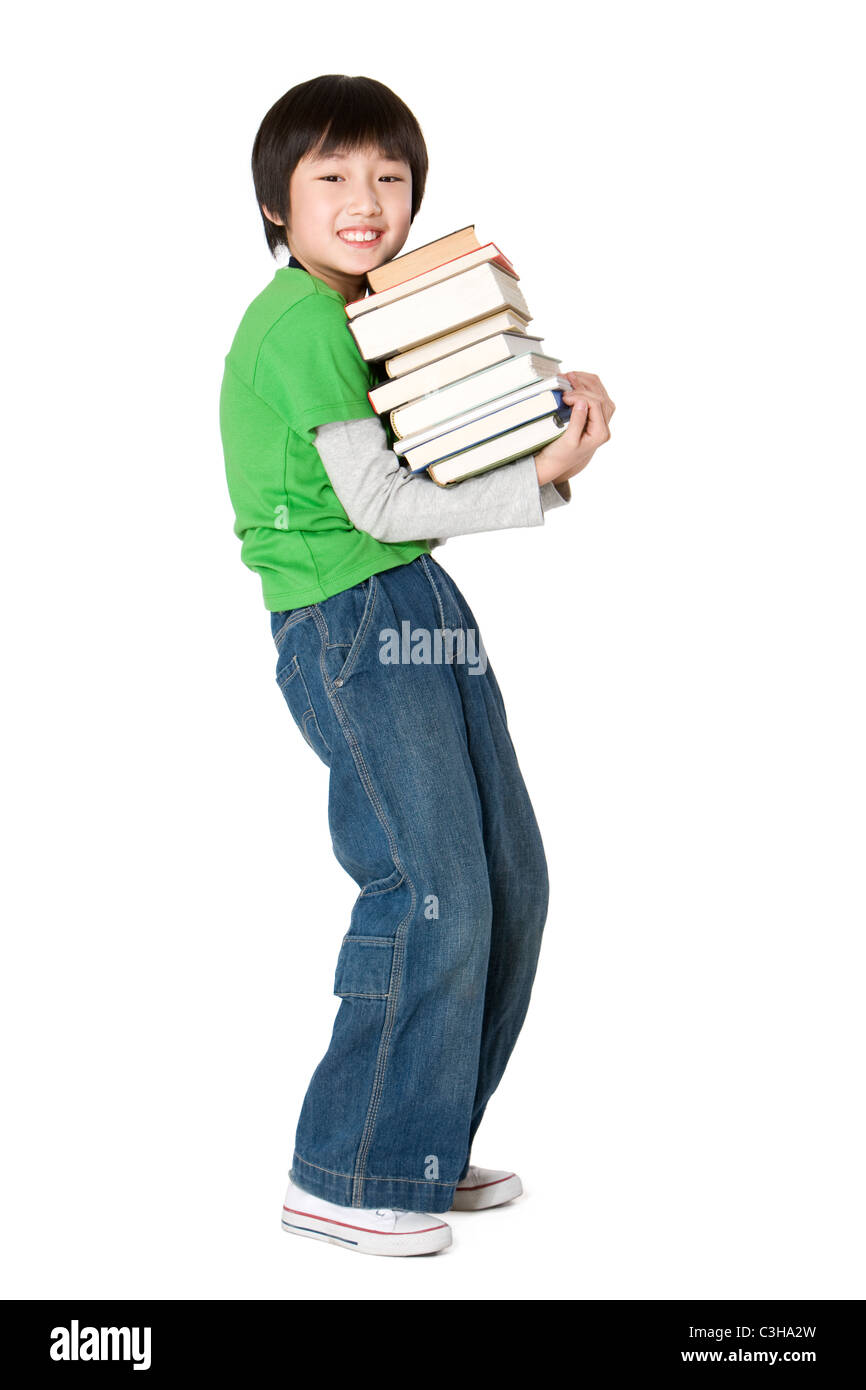 Young boy carrying a large stack of books Stock Photo - Alamy