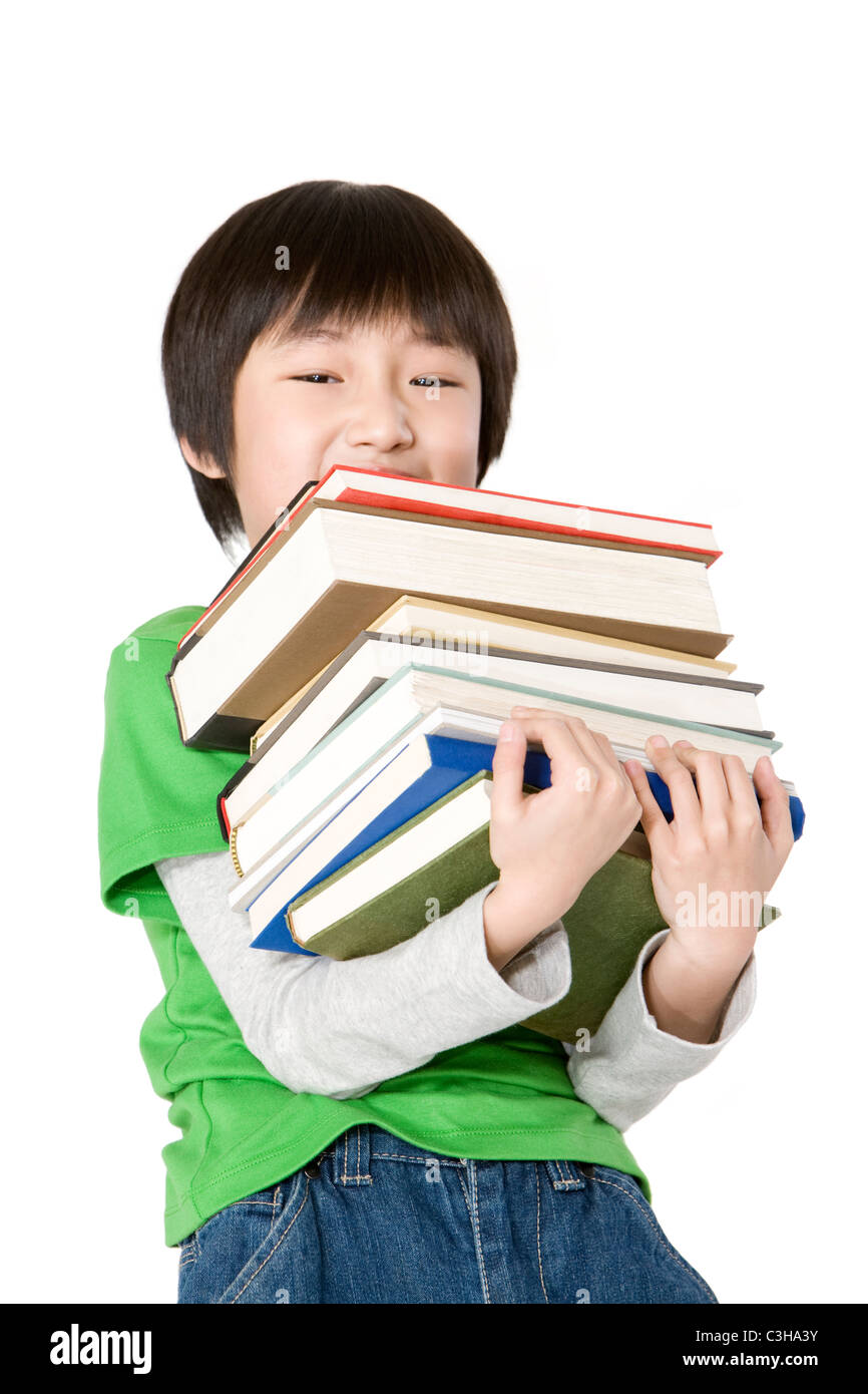 Young boy carrying a large stack of books Stock Photo - Alamy