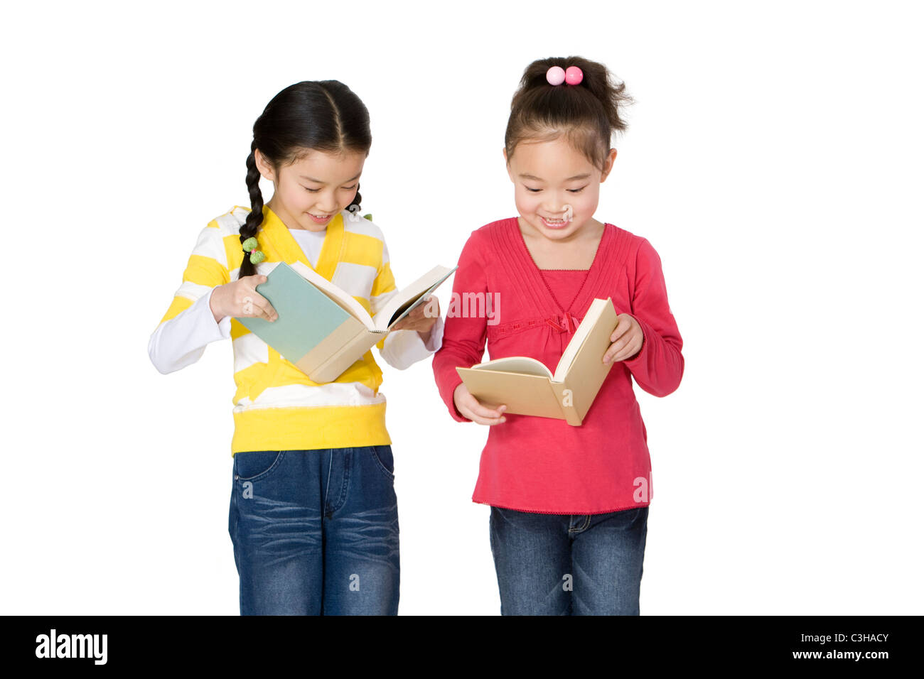 Two girls reading books together Stock Photo - Alamy