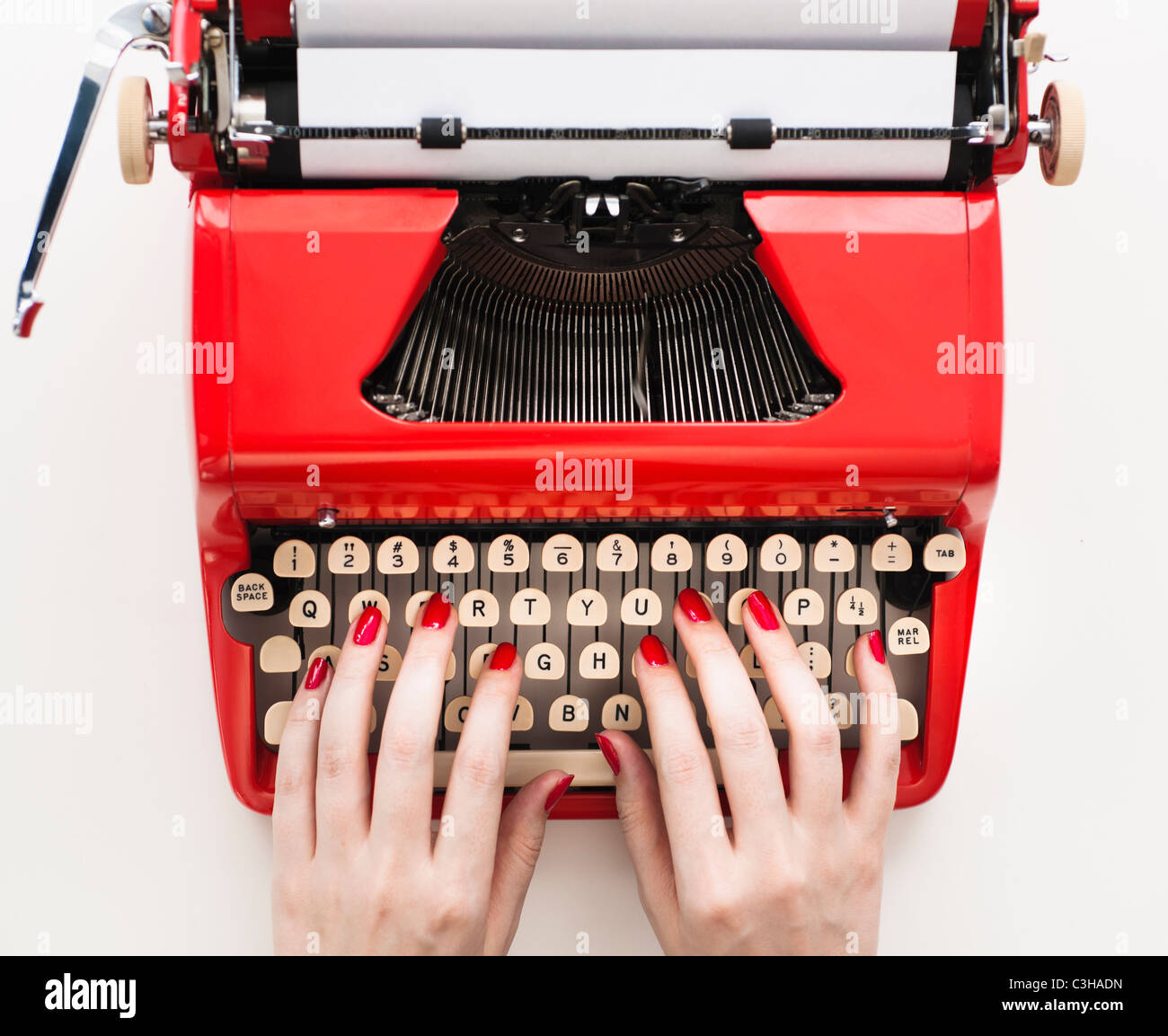 Close up of woman's hands with red nail polish typing on antique ...