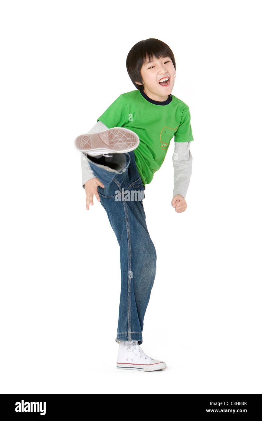Young boy kicking leg into the air Stock Photo - Alamy