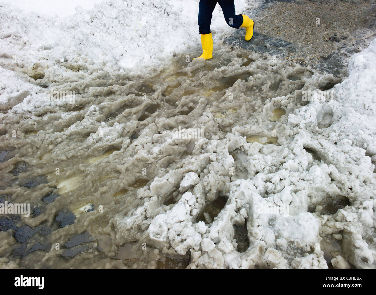 Legs of person in yellow rubber boots walking in slush Stock Photo - Alamy