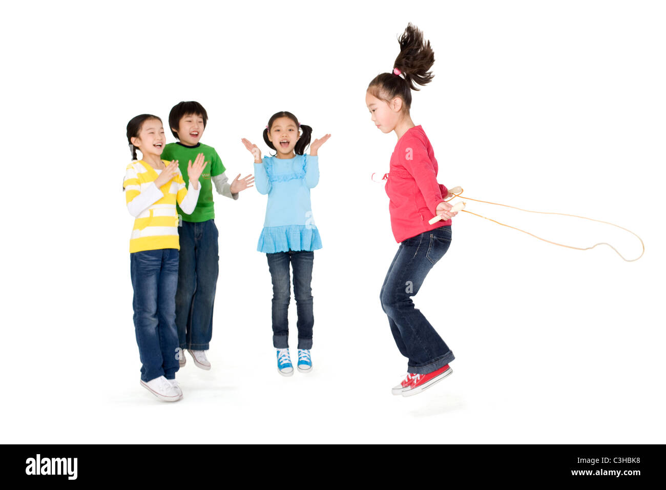 Friends cheering their friend as she jump ropes Stock Photo - Alamy