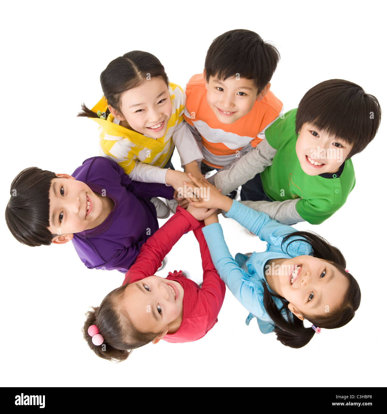 A group of children huddle with their hands in Stock Photo - Alamy