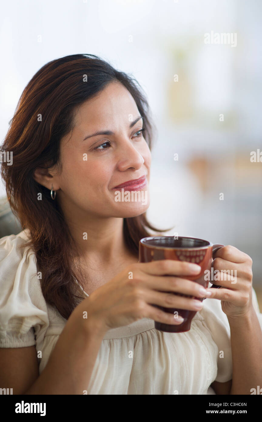 Portrait of smiling woman drinking tea Stock Photo - Alamy