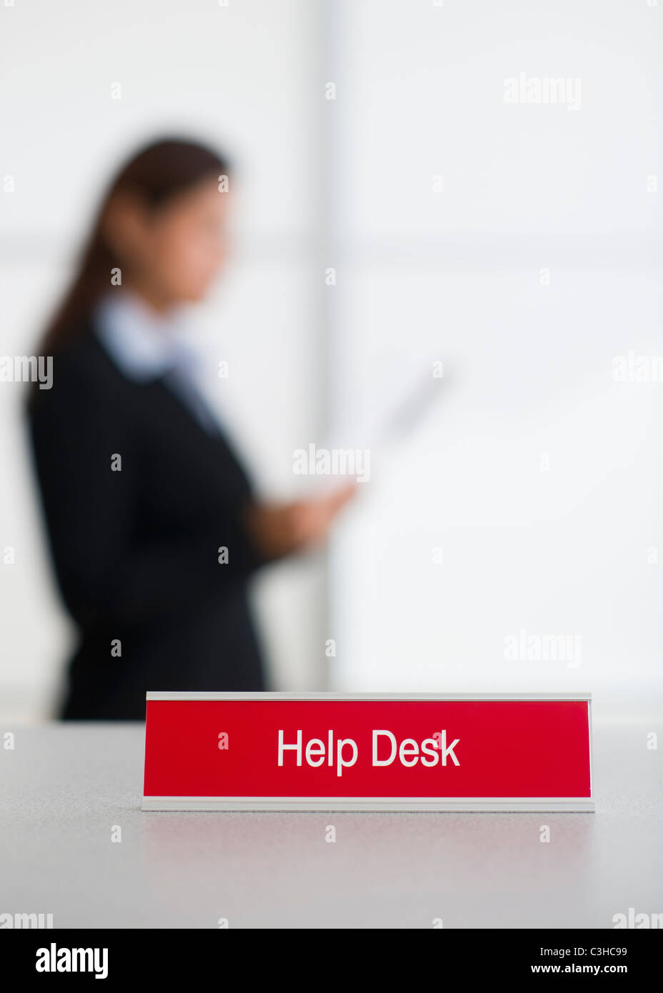 Help desk sign with defocused woman in background Stock Photo - Alamy