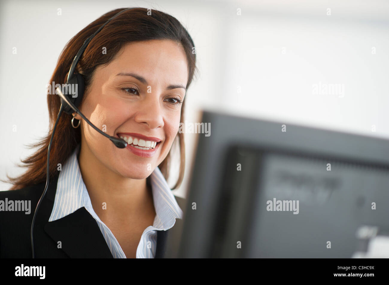 Smiling female customer service representative with headset Stock Photo ...