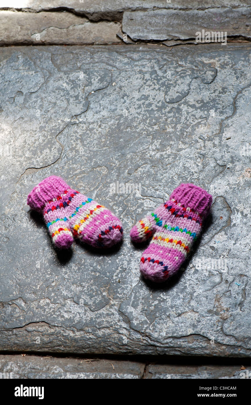 Young Girls colourful striped mittens on a slate floor Stock Photo - Alamy
