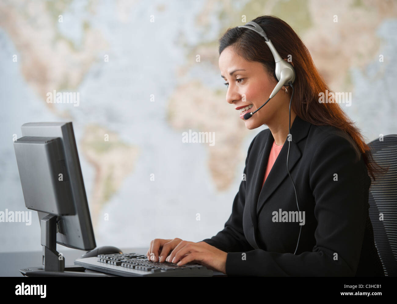 Female customer service representative with headset working on computer ...