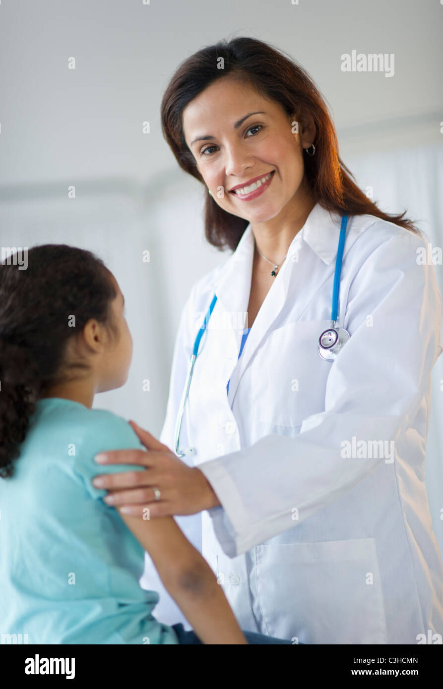 Female pediatrician examining girl (6-7) in doctor's office Stock Photo ...