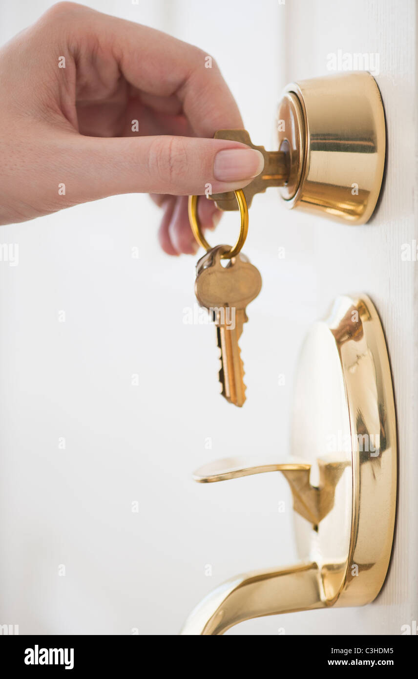 Woman opening door lock Stock Photo - Alamy