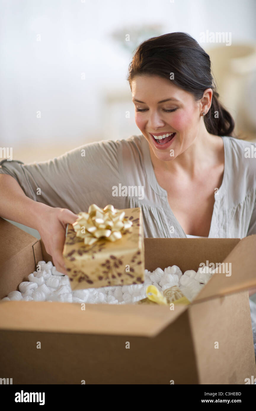 Young woman opening box with gift Stock Photo - Alamy