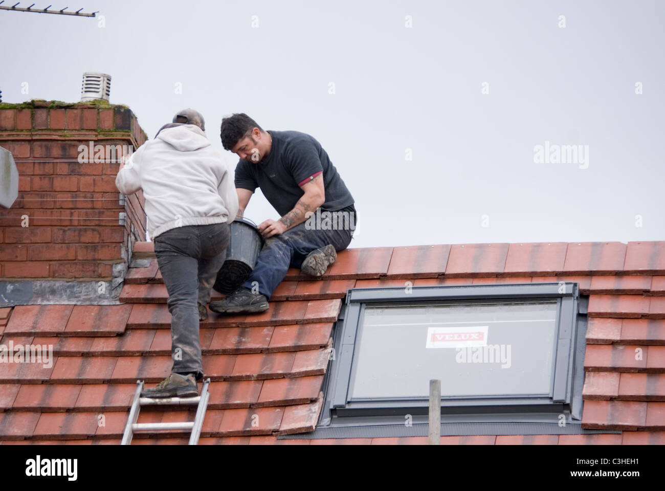 Roofer Laying Ridge Tiles with Mortar Completing Re Roofing Residential ...