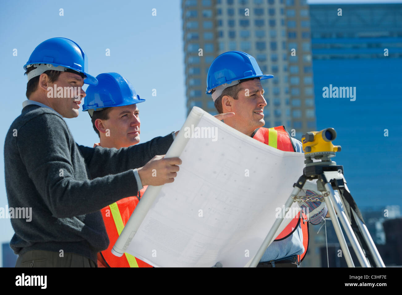 Construction workers reading blueprint Stock Photo - Alamy