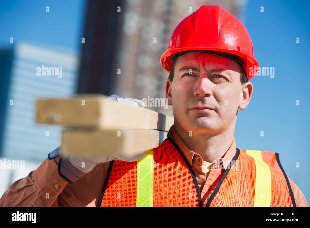 Construction worker carrying planks Stock Photo - Alamy