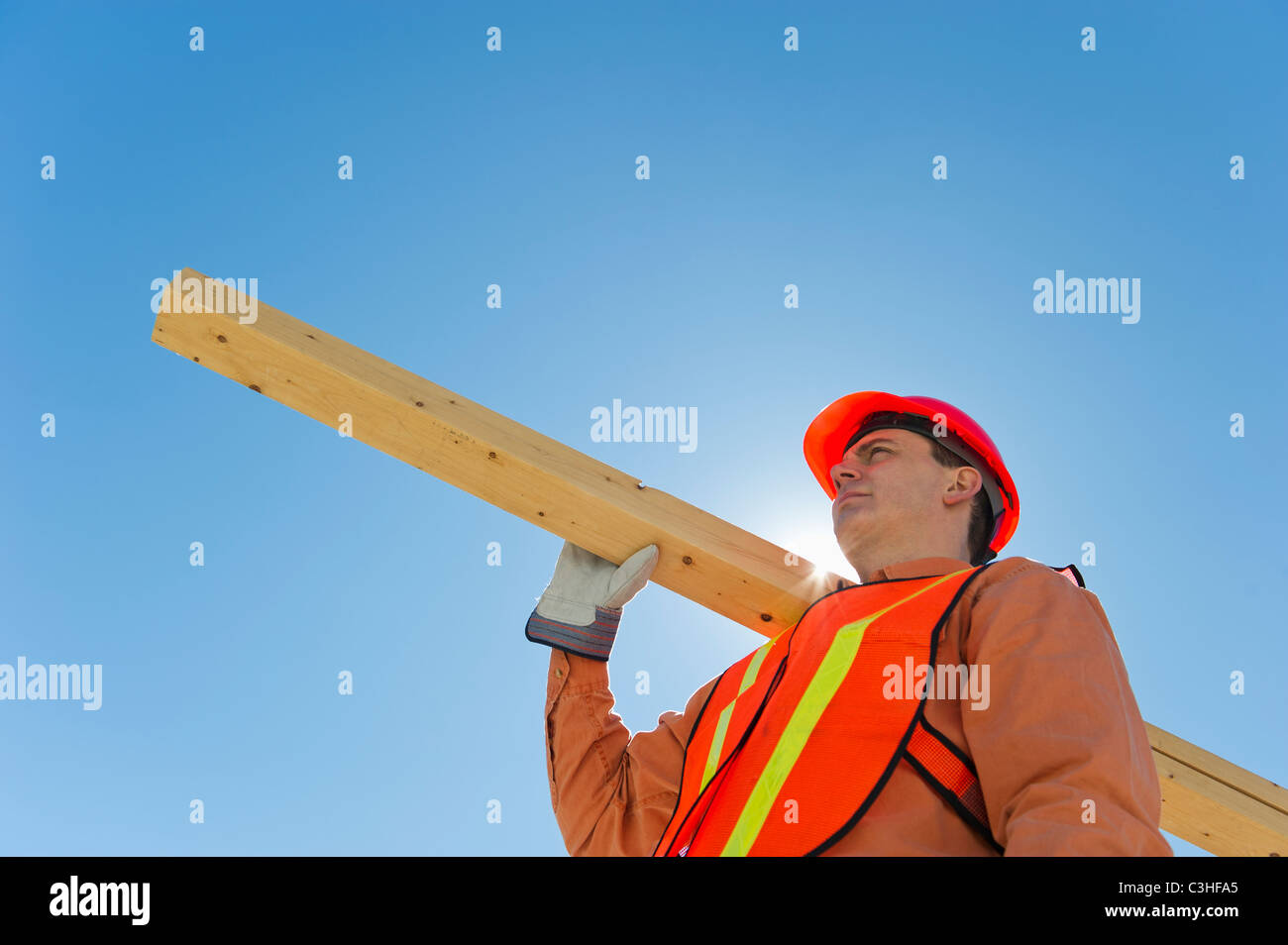 Construction worker carrying planks Stock Photo - Alamy