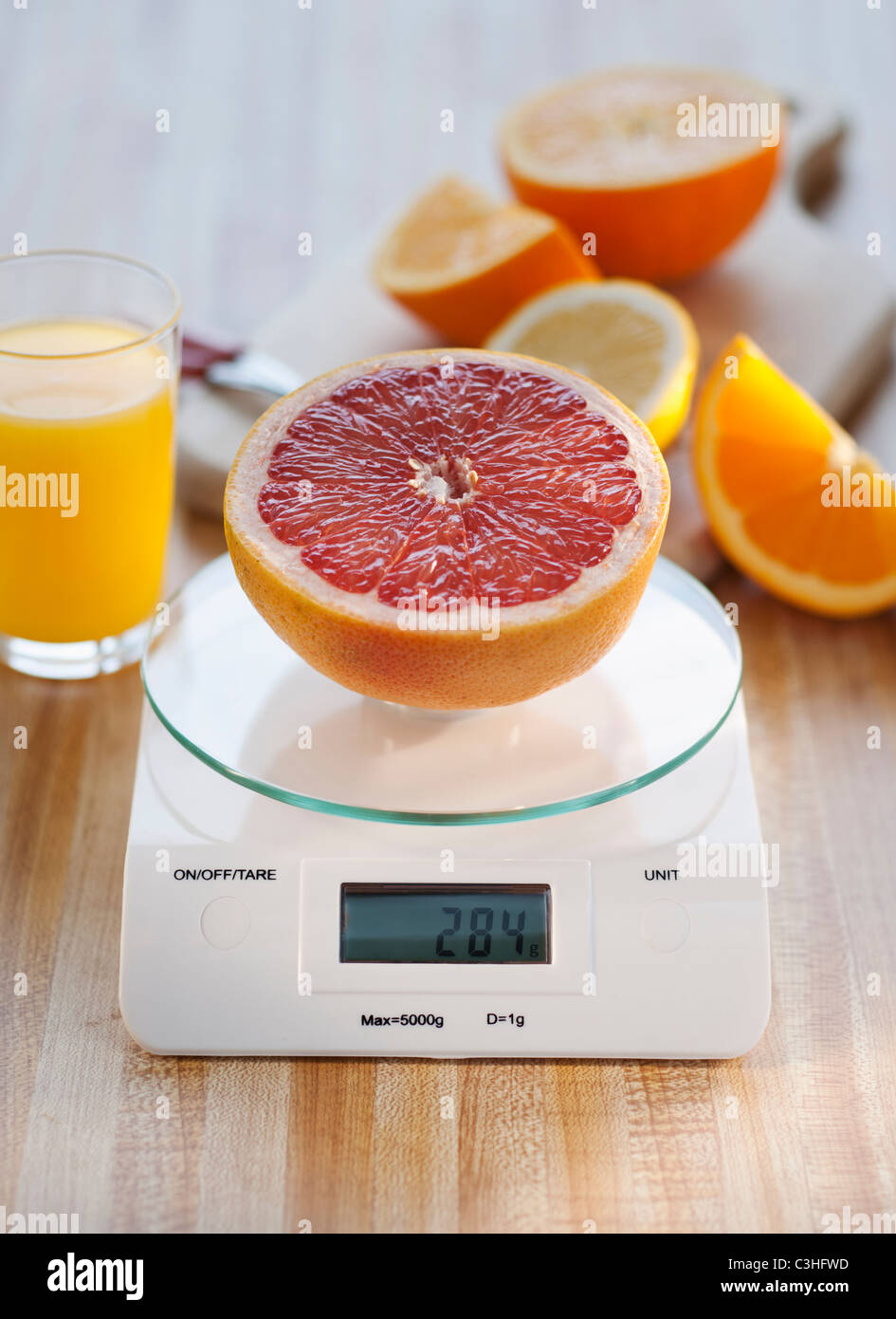 Half of grapefruit on weight scale Stock Photo - Alamy