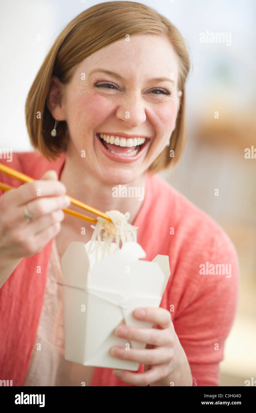 Woman eating Chinese take out food Stock Photo - Alamy