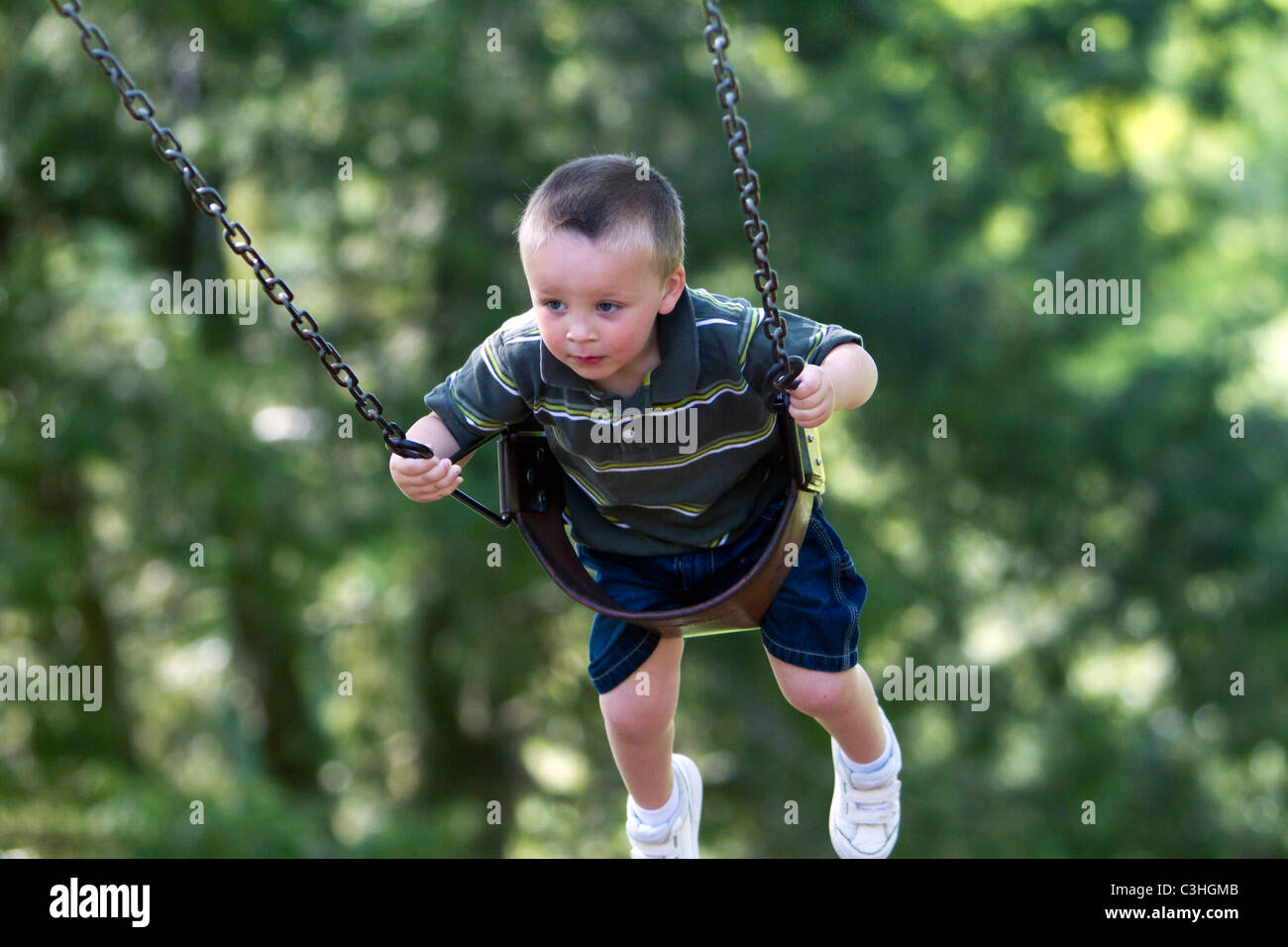 A little boy swinging on a swing Stock Photo - Alamy