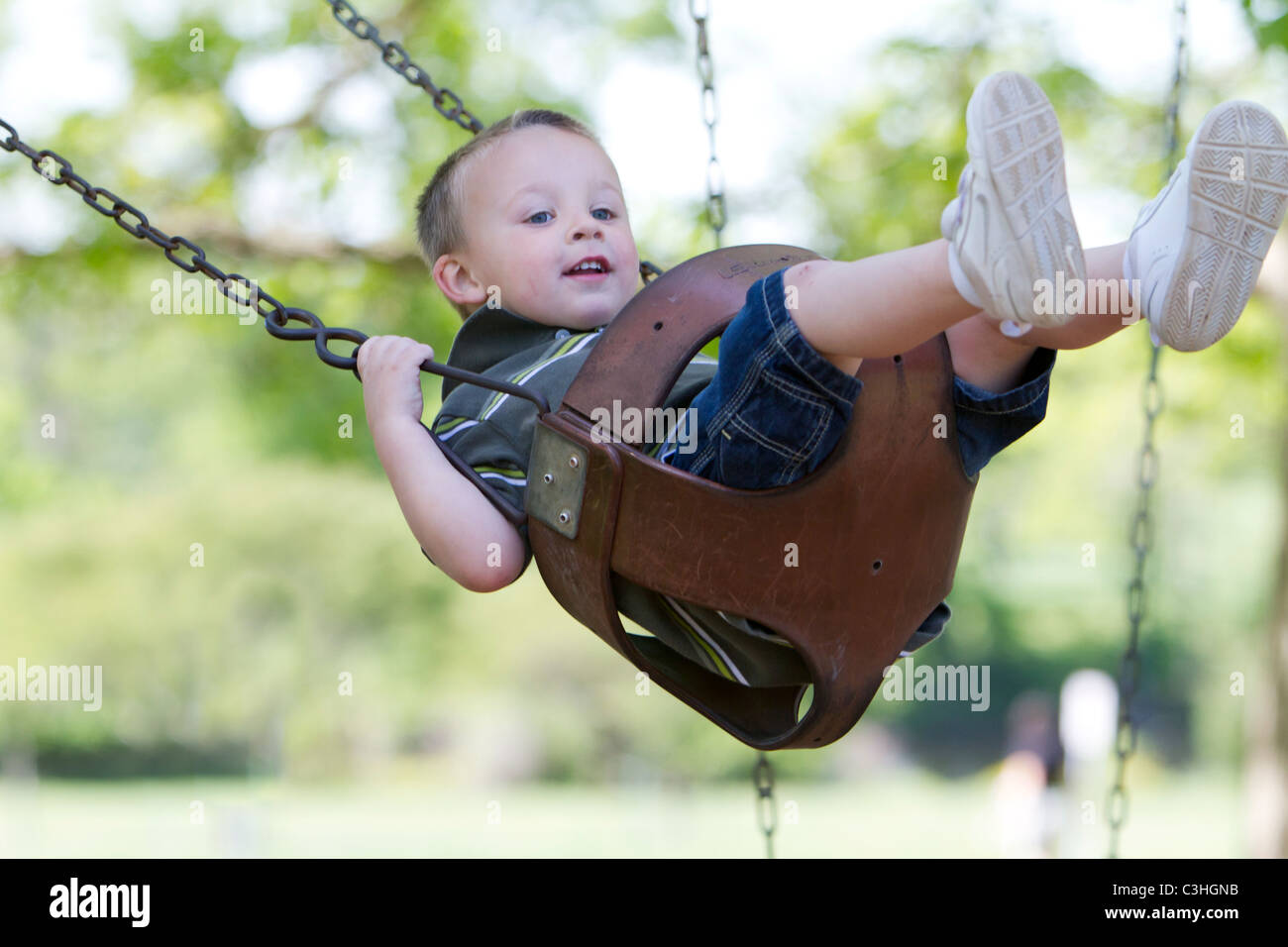A little boy swinging on a swing Stock Photo - Alamy