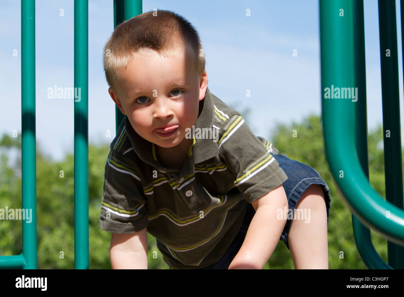 A young boy playing on a jungle gym in the park Stock Photo - Alamy