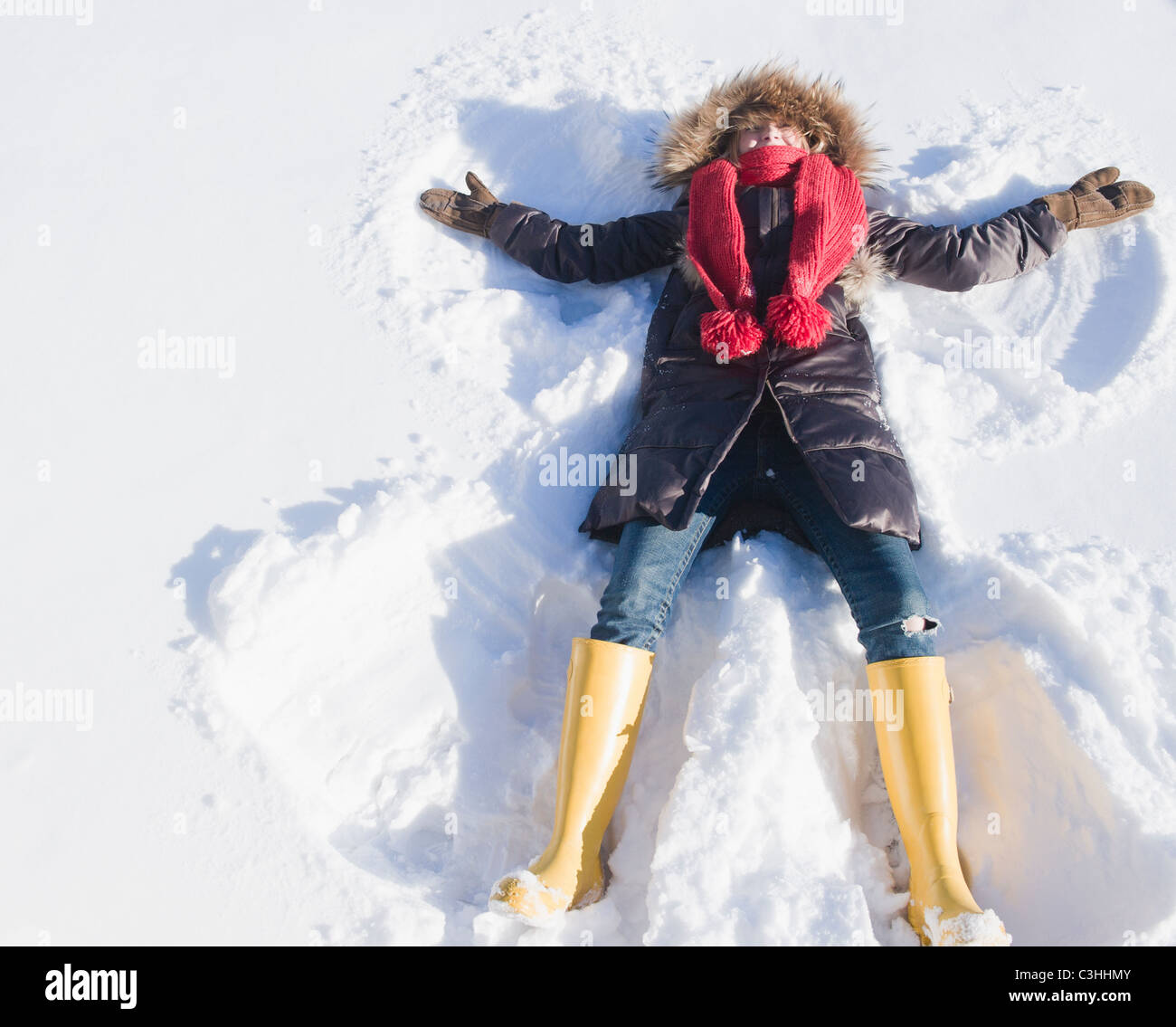 Young woman doing snow angel Stock Photo - Alamy