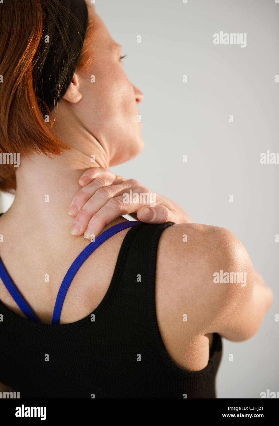 Woman rubbing neck Stock Photo - Alamy