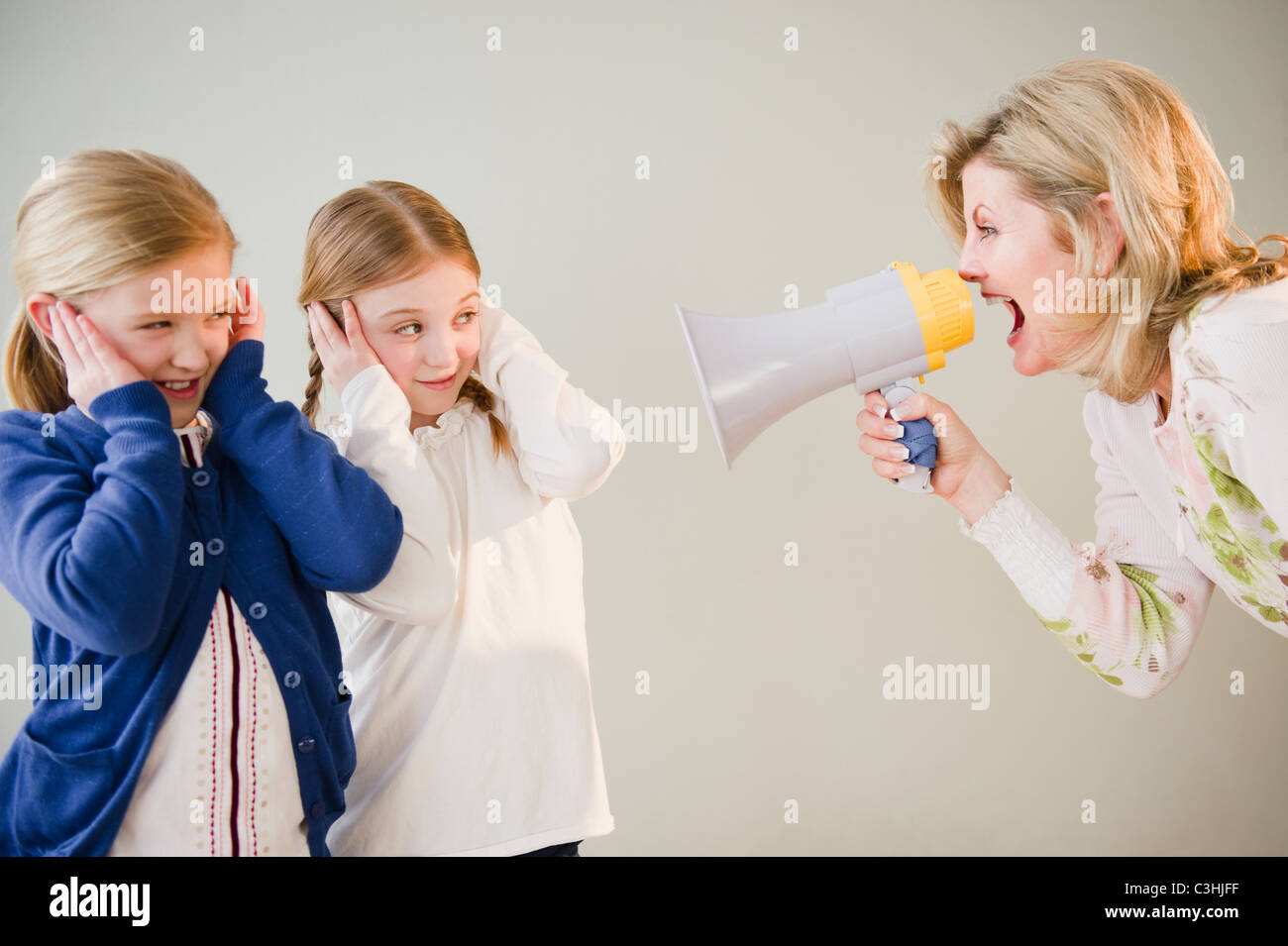 Mother shouting at daughters (8-11) through bullhorn Stock Photo - Alamy