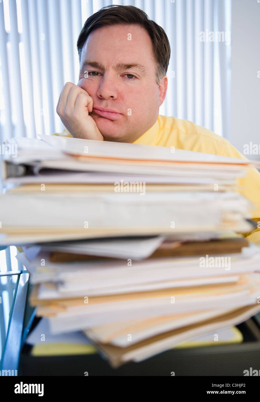 Businessman behind stack of paperwork Stock Photo - Alamy