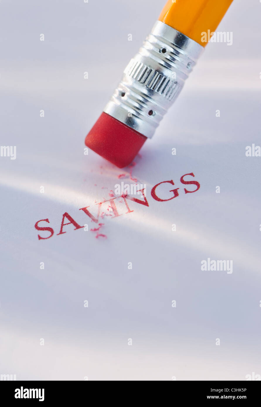 Studio shot of pencil erasing the word savings from piece of paper ...