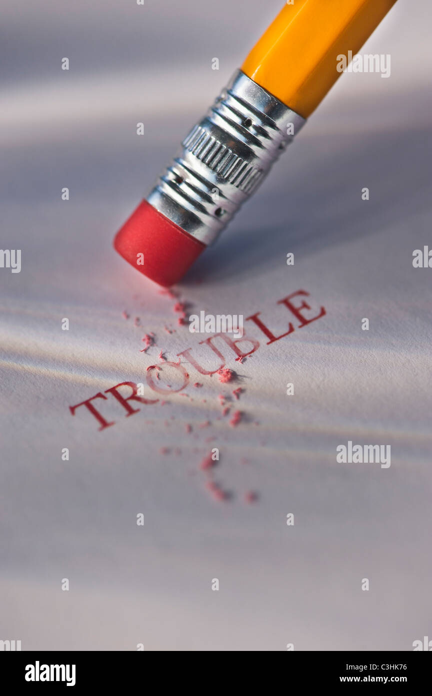 Studio shot of pencil erasing the word trouble from piece of paper ...