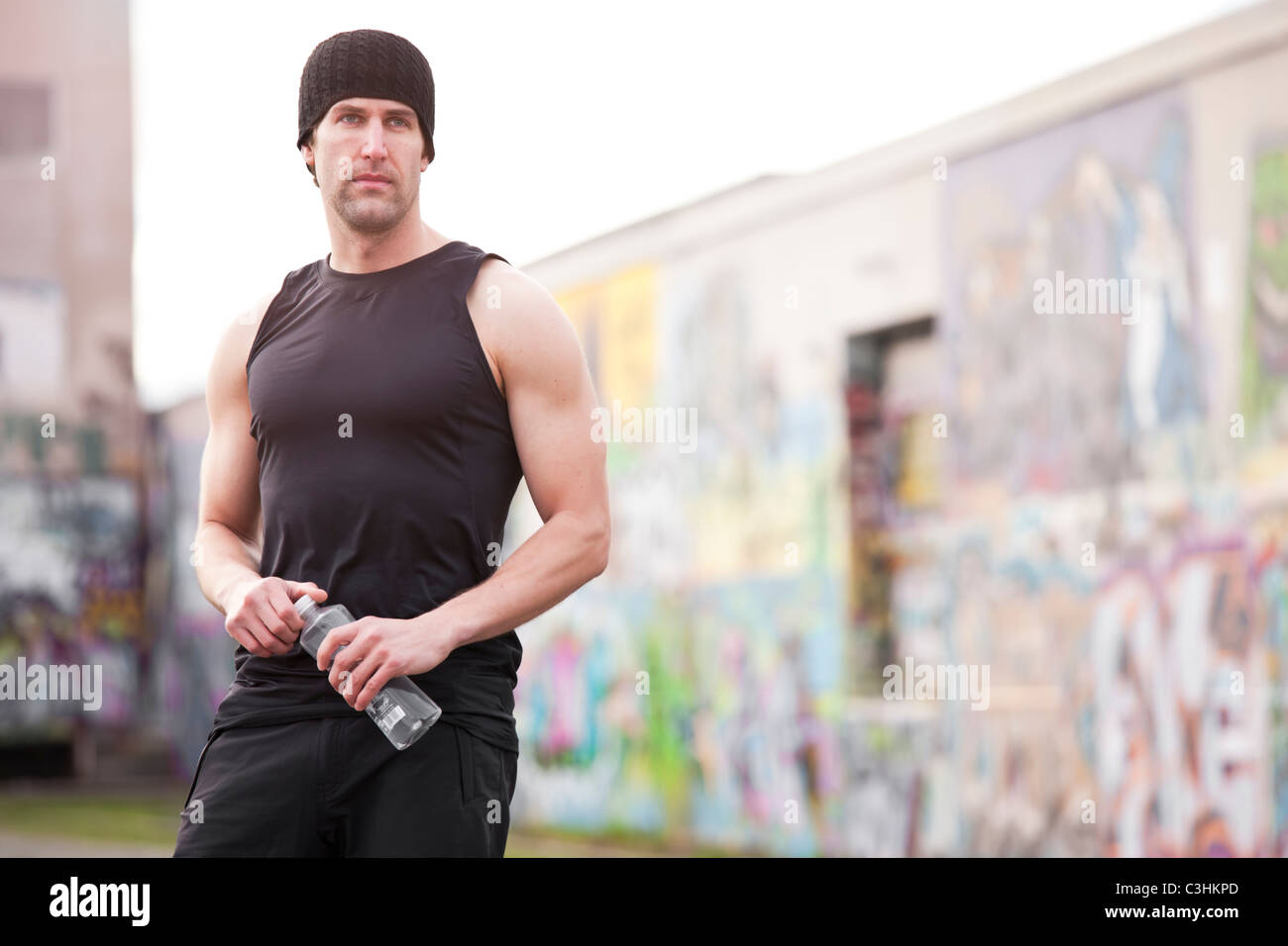 Man in workout wear in front of graffiti wall Stock Photo - Alamy