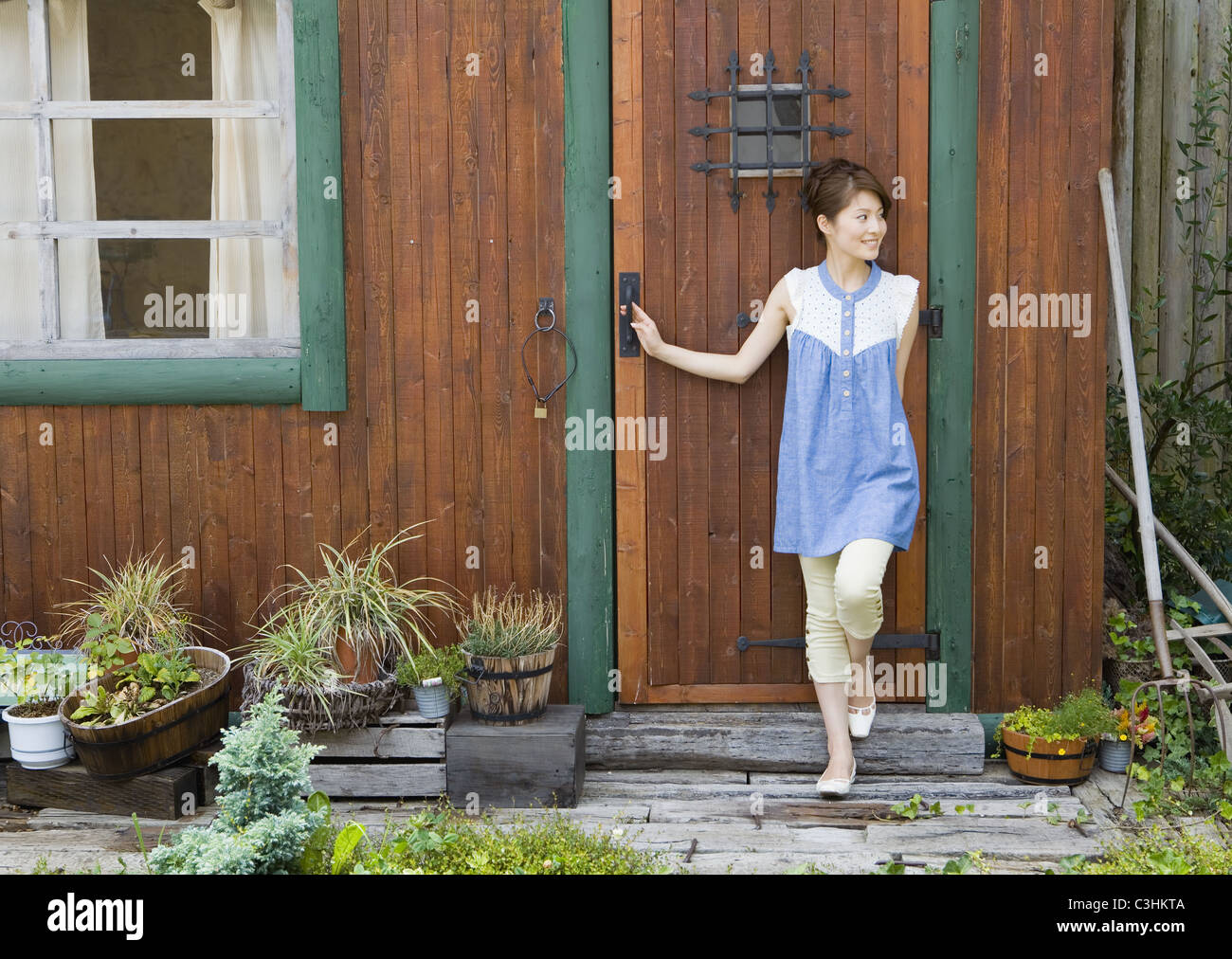 Young woman standing at front door Stock Photo - Alamy