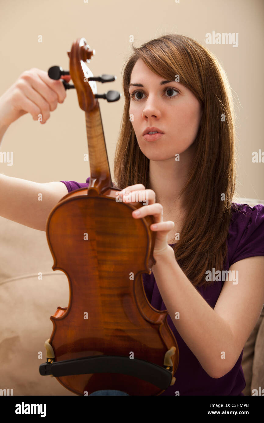 Young woman tuning violin Stock Photo - Alamy