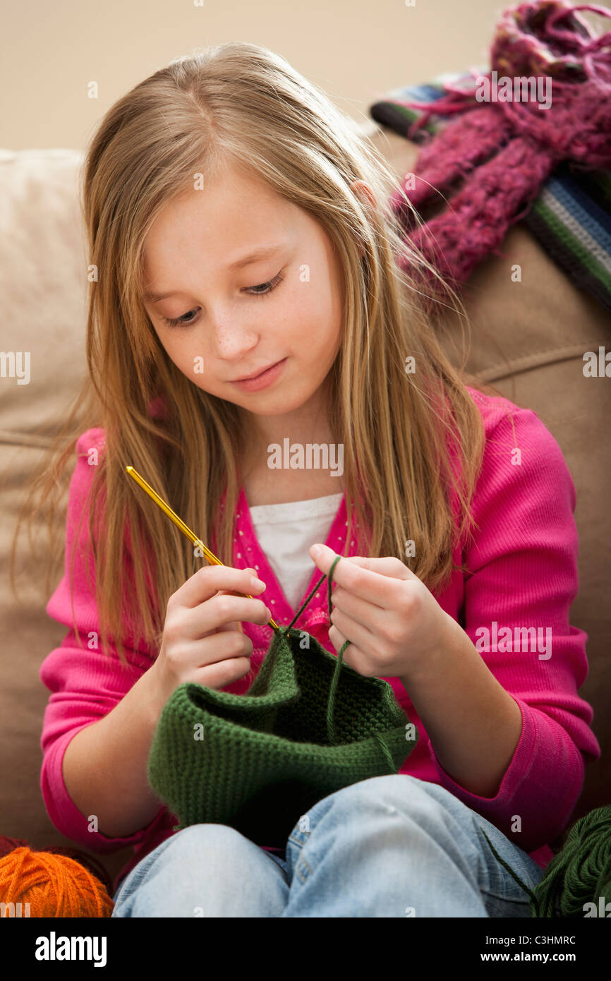 Girl (8-9) knitting woolly hat Stock Photo - Alamy