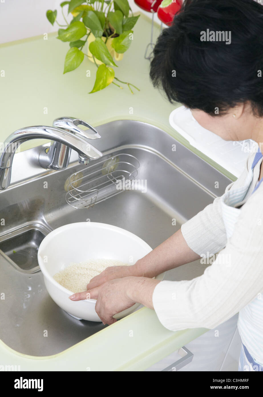 Woman washing rice Stock Photo - Alamy