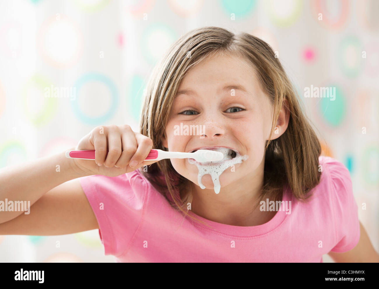 Girl (10-11) brushing teeth in messy way Stock Photo - Alamy