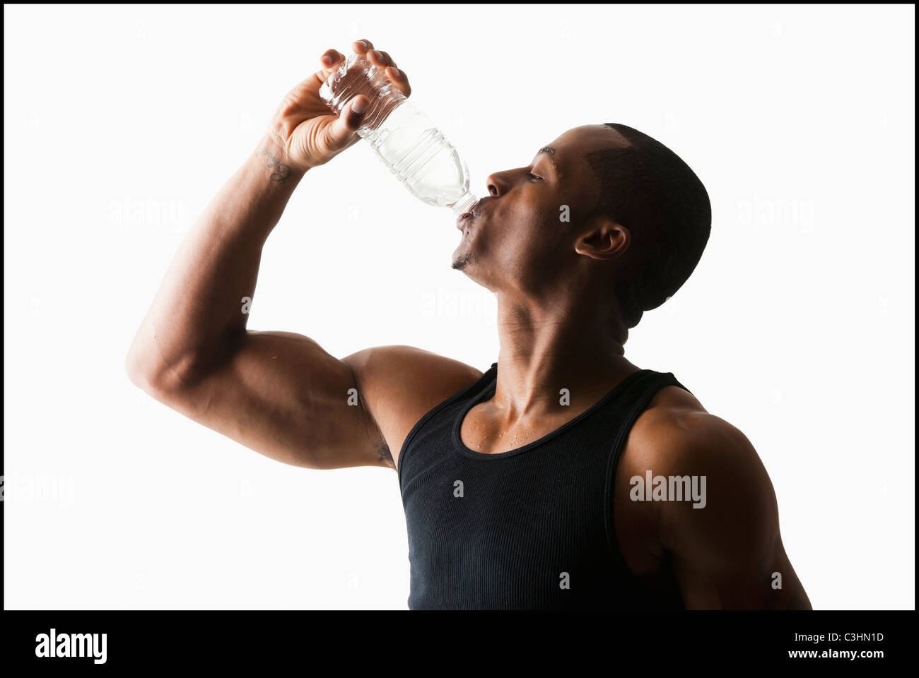 Studio shot of man drinking water from bottle Stock Photo - Alamy