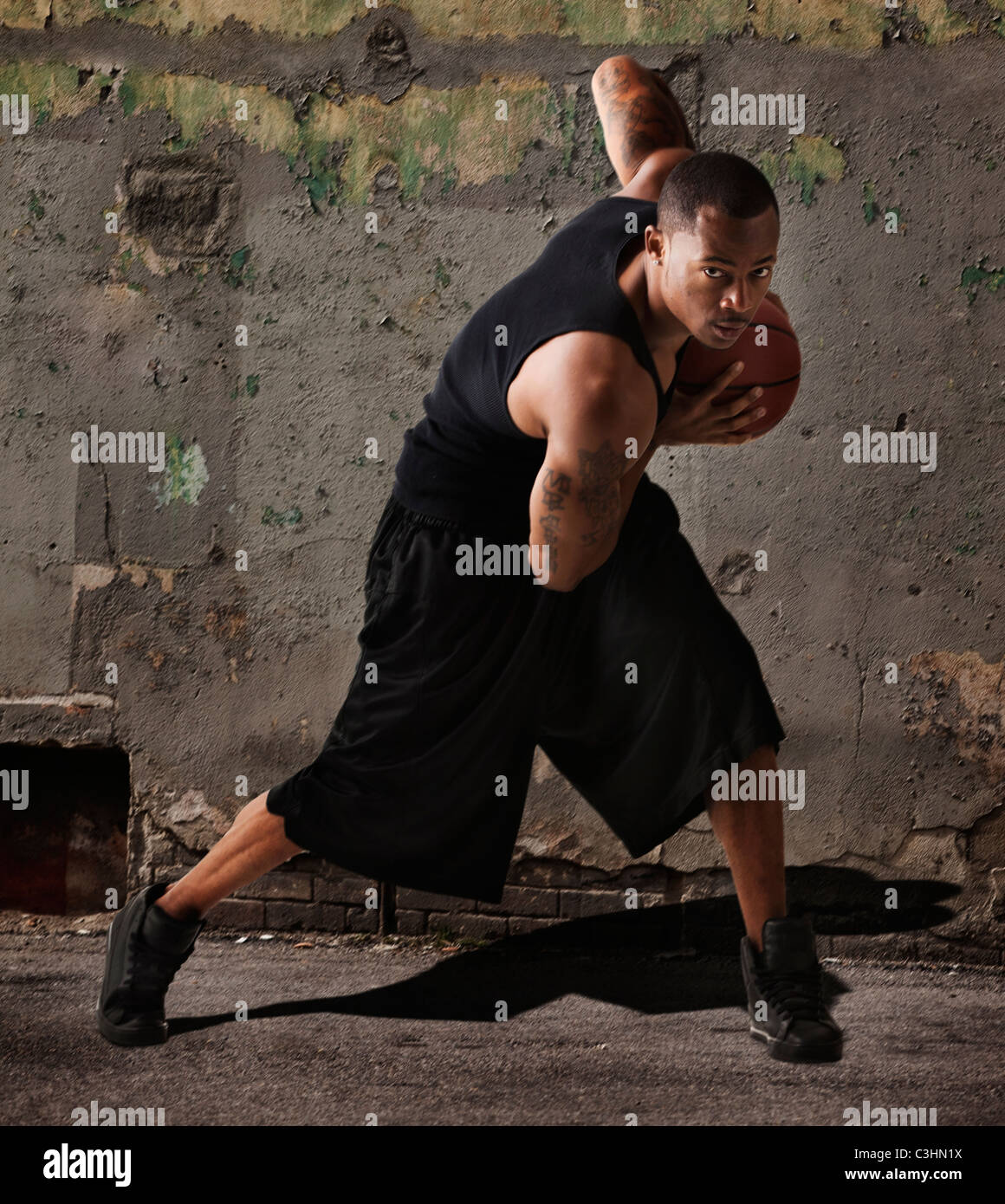 Man playing basketball in front of wall Stock Photo - Alamy
