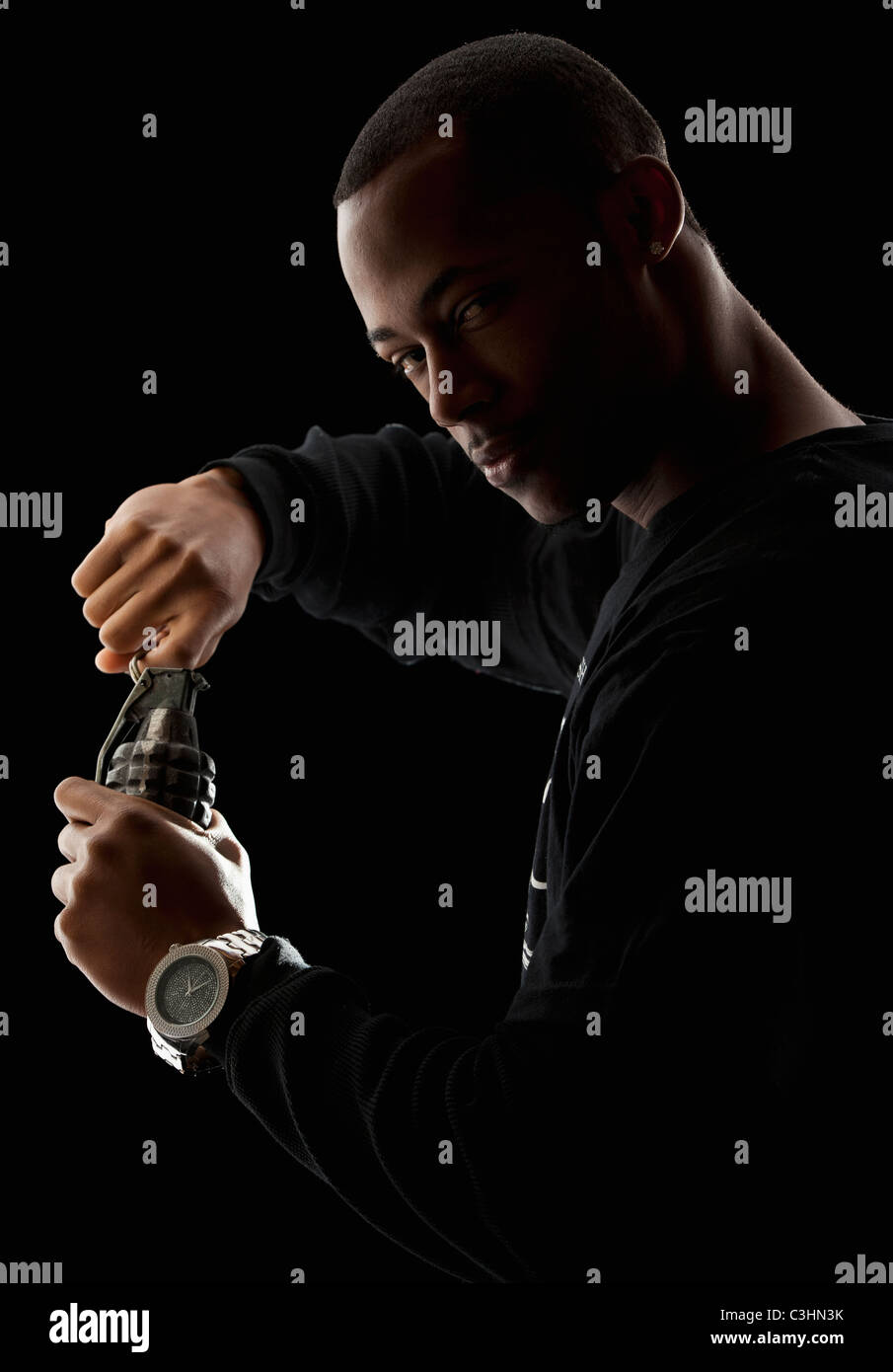 Studio portrait of young man holding grenade Stock Photo - Alamy