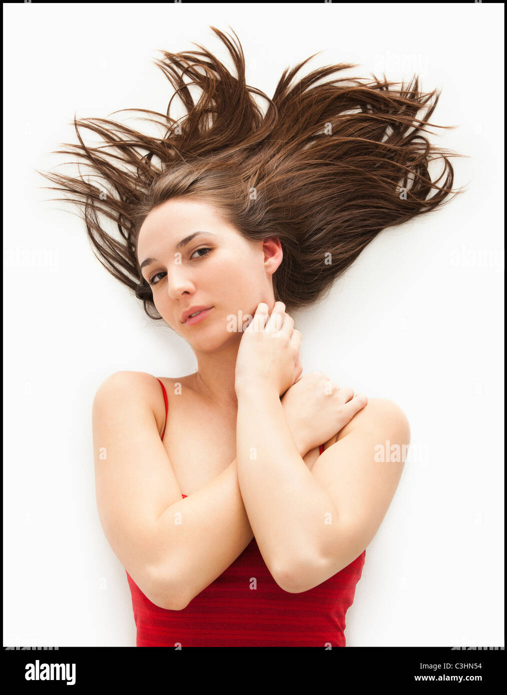 Studio portrait of young woman with windswept hair Stock Photo - Alamy