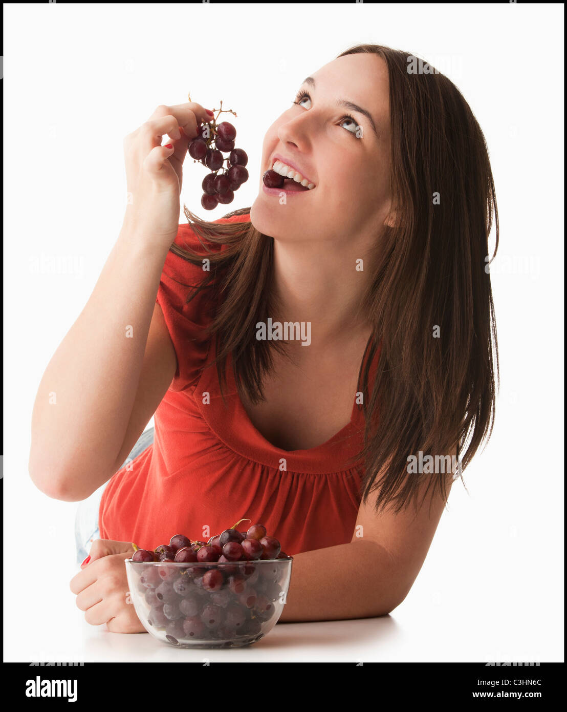Young woman eating grapes Stock Photo - Alamy